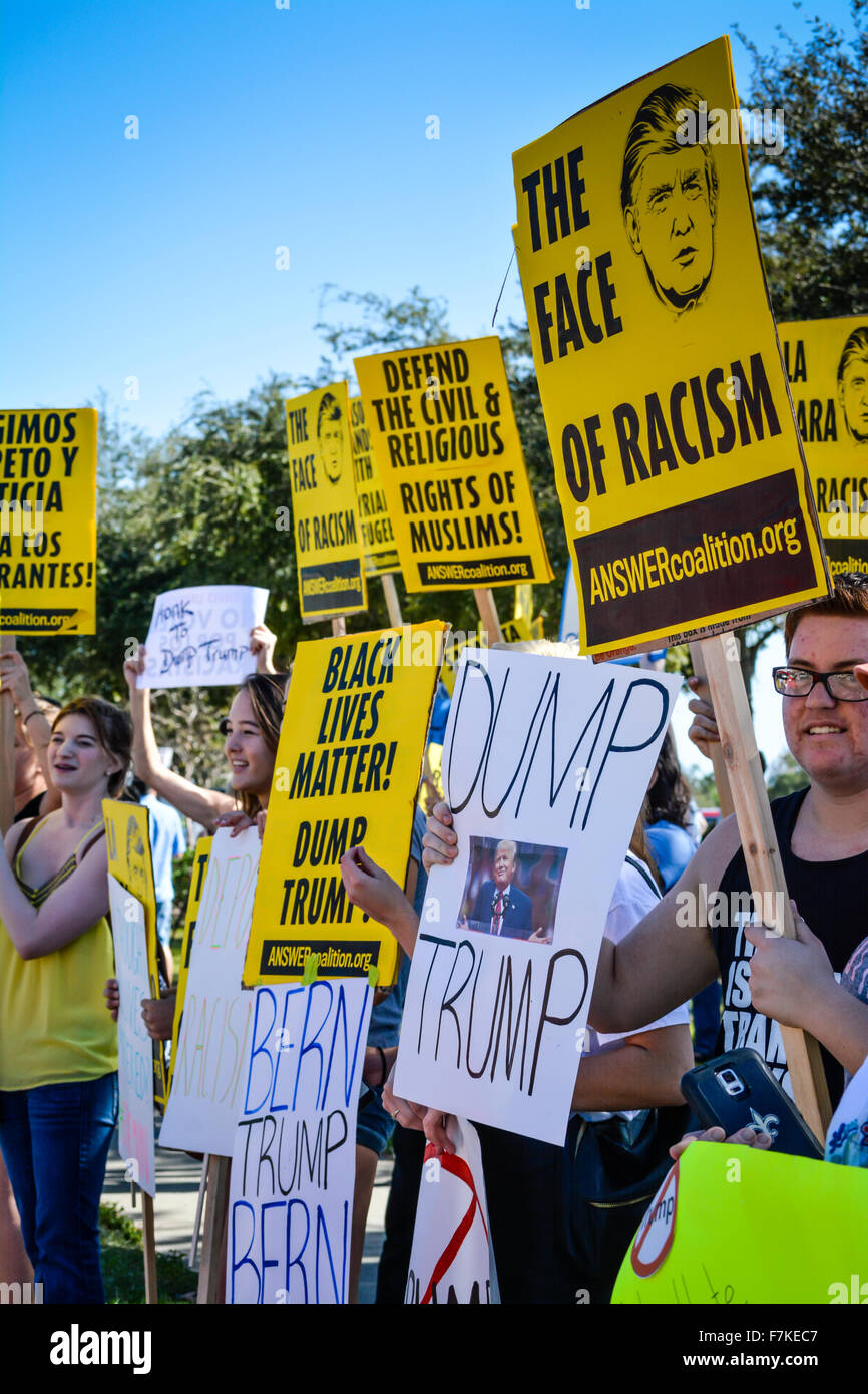 Protesters holding signs denouncing Donald Trump at a political rally ...