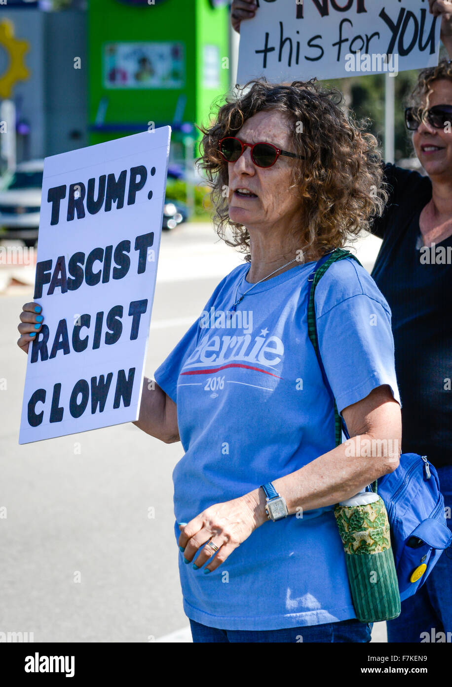 Protesters holding signs denouncing Donald Trump at a political rally ...