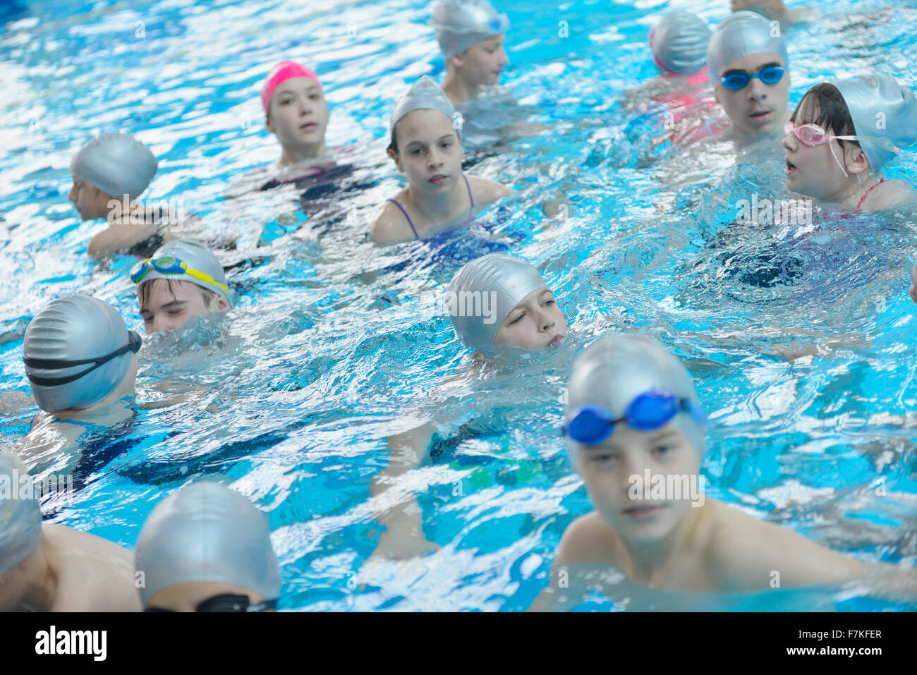 group of happy kids children at swimming pool class learning to swim ...