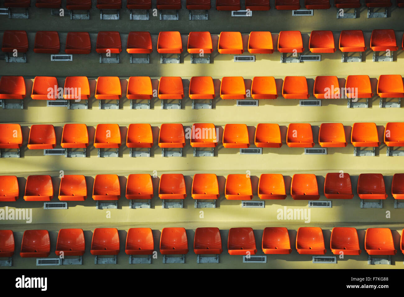 many empty orange seats in sport arena representing audience and crowd ...