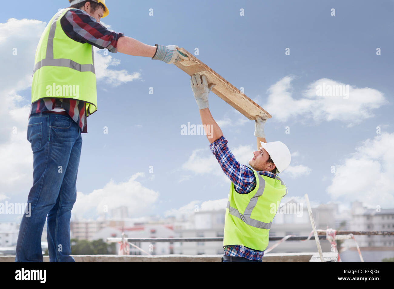 Construction workers lifting part at highrise construction site Stock ...