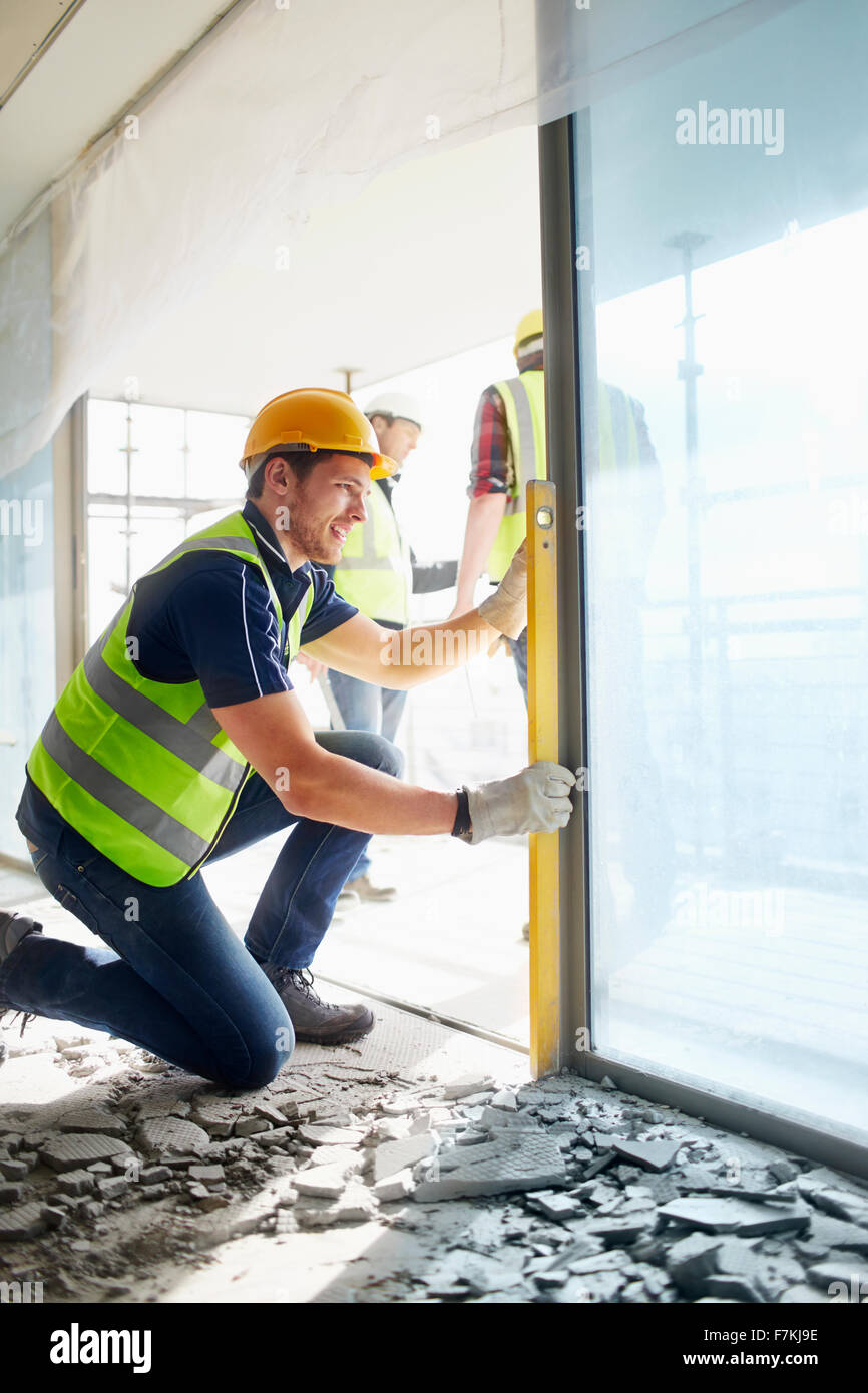 Construction worker using level tool at construction site Stock Photo ...