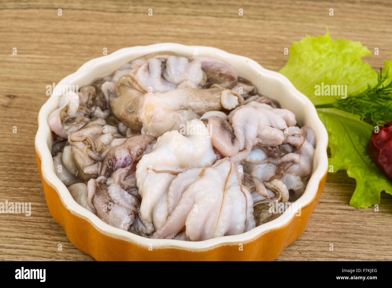 Raw baby octopus in the bowl ready for cooking Stock Photo - Alamy
