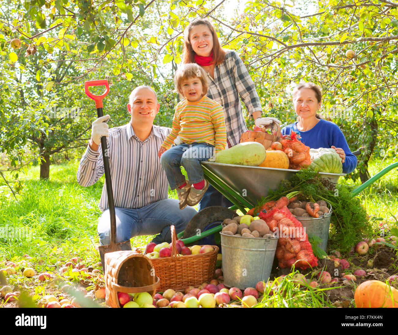 Happy family with harvest in vegetable garden Stock Photo - Alamy