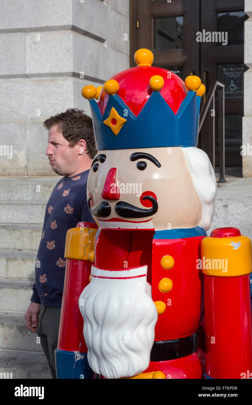 Washington, DC - A man smoking a cigarette stands next to a giant ...