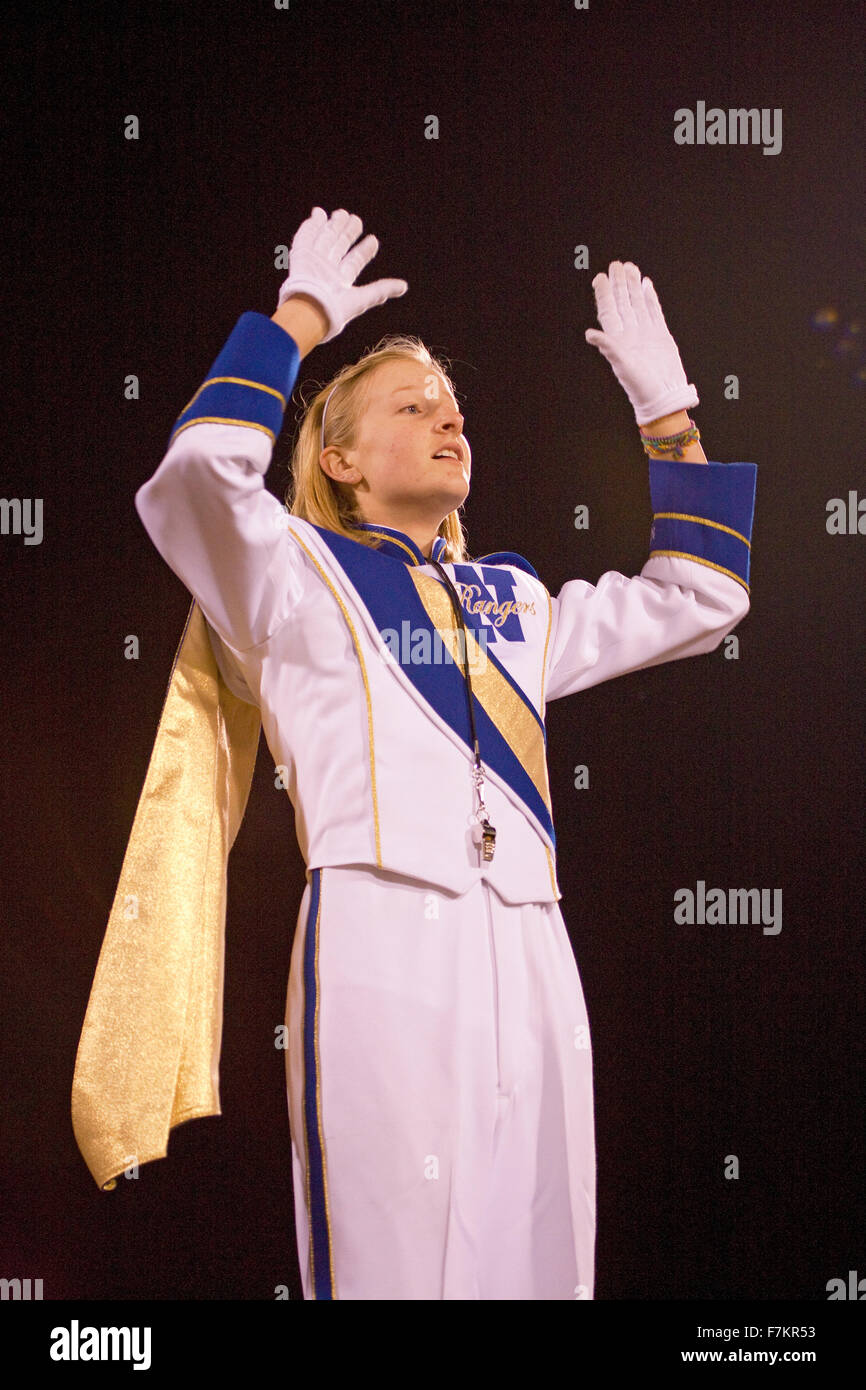 High school marching band conductor conducts band for football game ...