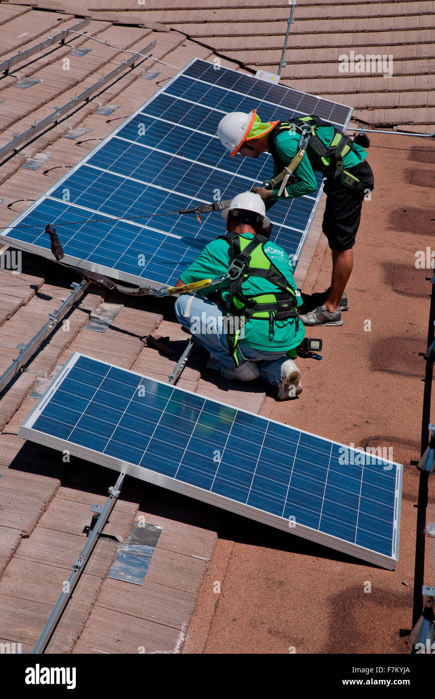 Two male solar workers install solar panels on home in Oak View ...