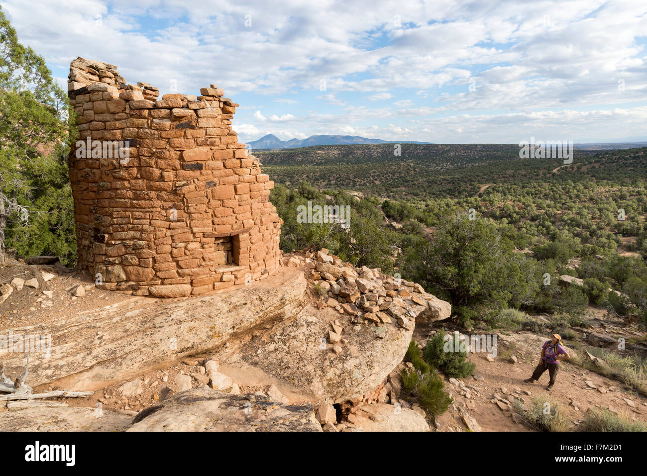 Hiker looking at Painted Hand Pueblo, an ancestral puebloan structure ...