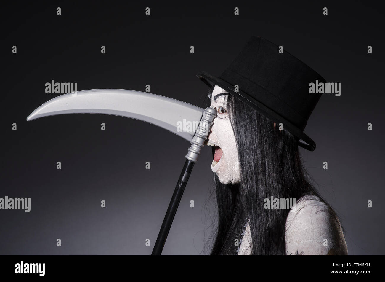 Woman in halloween concept with scythe Stock Photo - Alamy