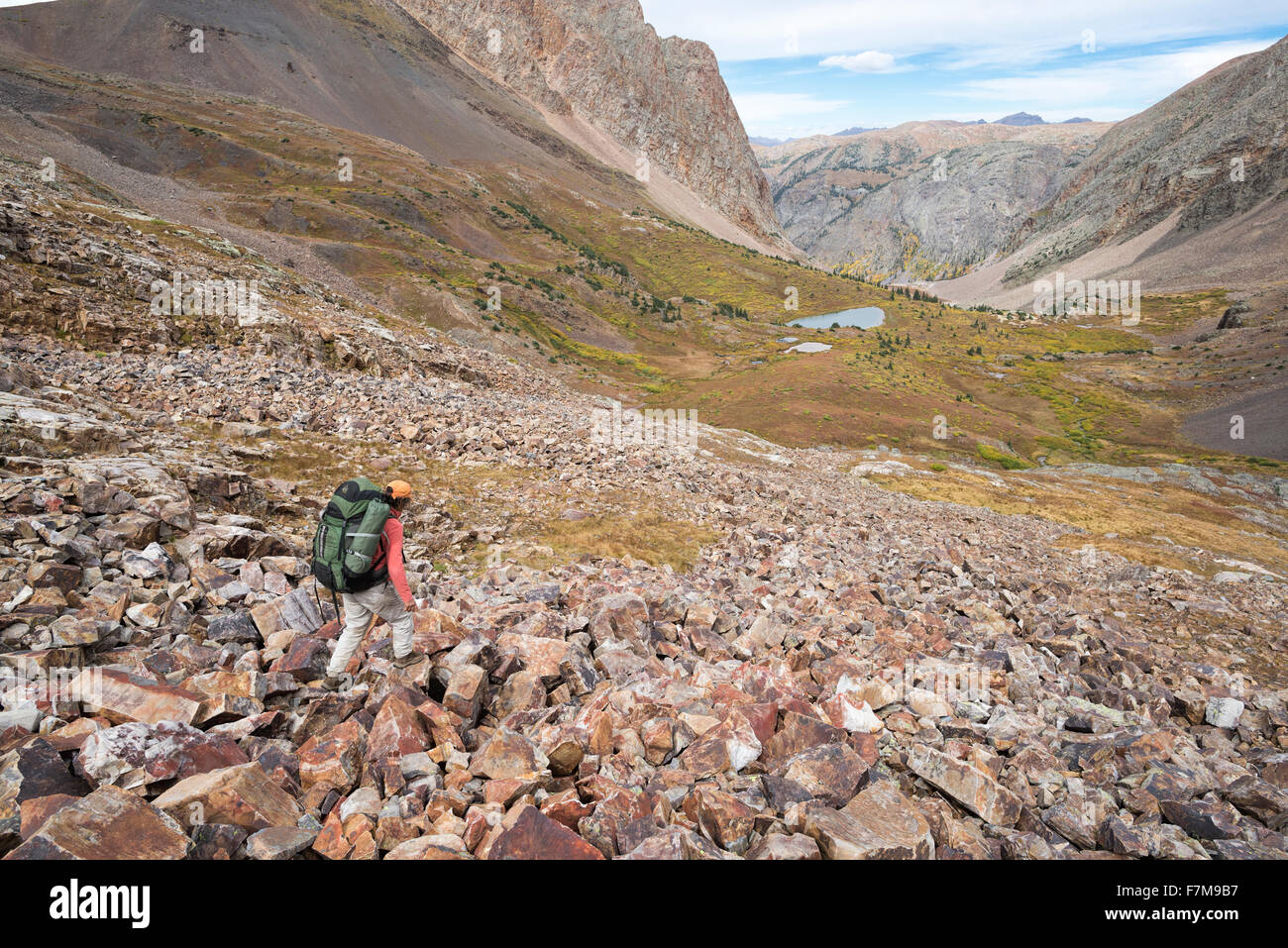 Backpacker hiking on a talus slope in Colorado's Weminuche Wilderness ...
