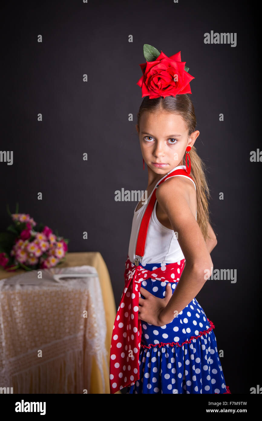 Young girl with flamenco outfit and sober look on black background ...