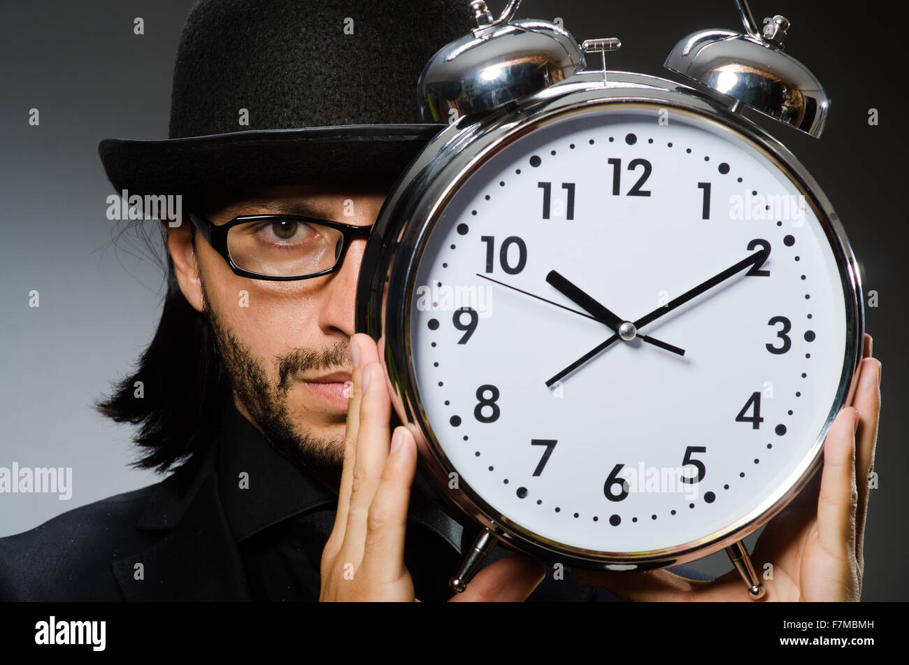 Man with clock wearing vintage hat Stock Photo - Alamy