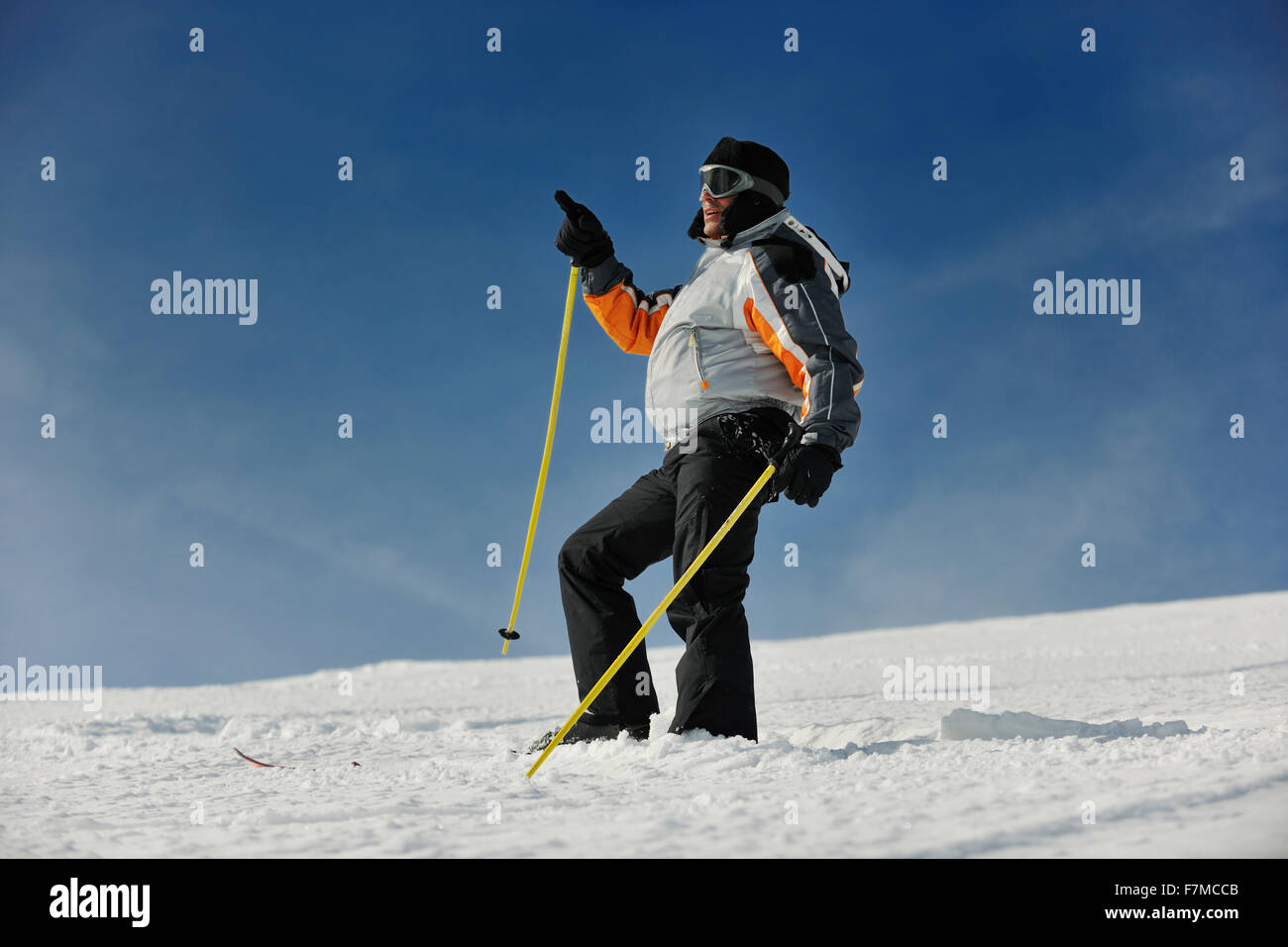 young man pointing direction on winter season during recration ski on ...
