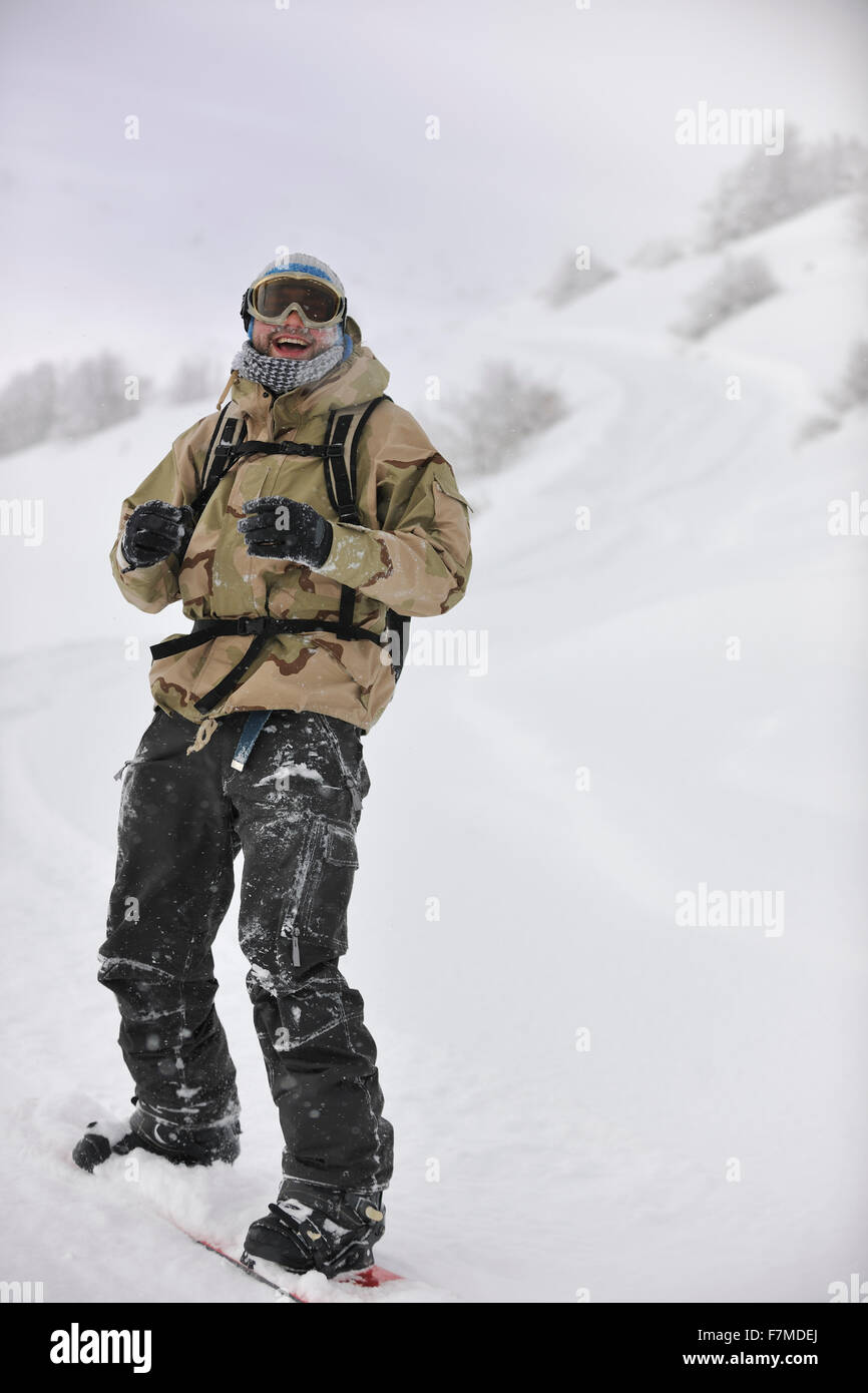 young skier relaxing in snow and looking mountain range at beautiful ...