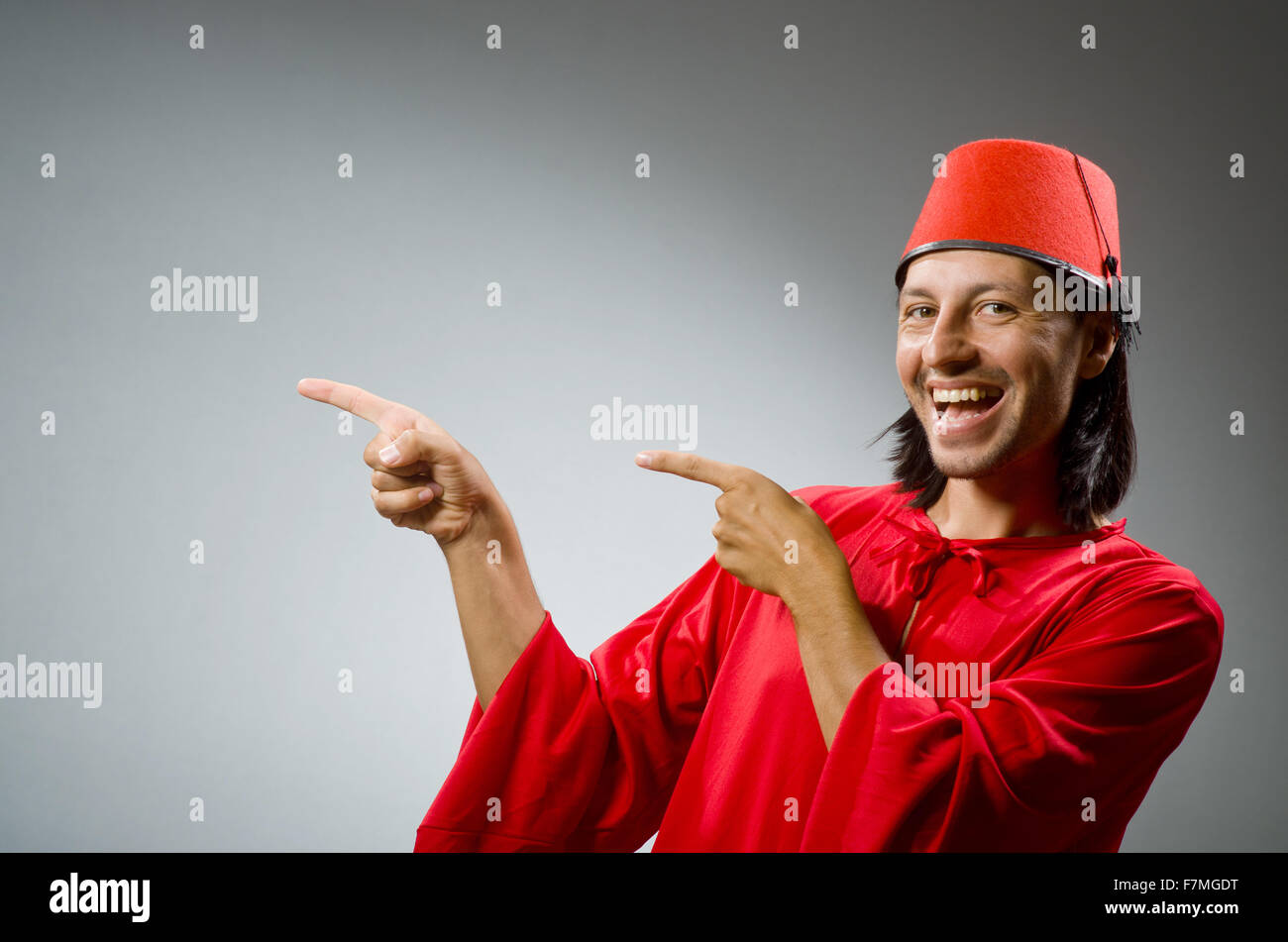 Funny man in red dress wearing fez hat Stock Photo - Alamy
