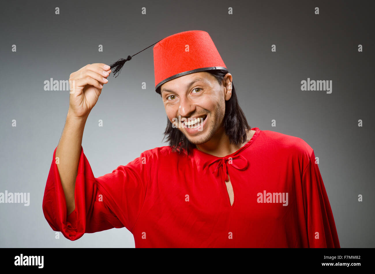 Funny man in red dress wearing fez hat Stock Photo - Alamy