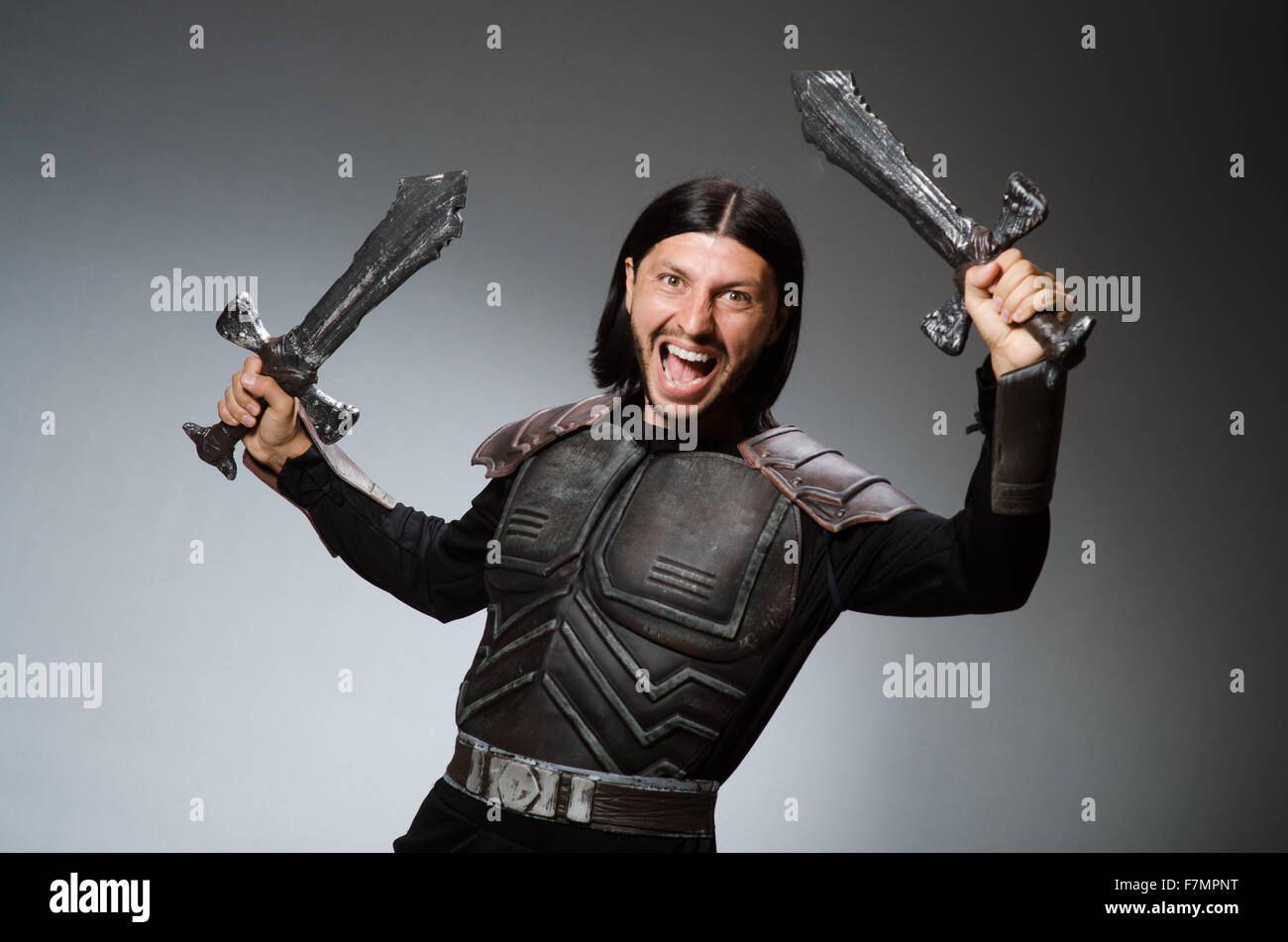 Angry knight with sword against dark background Stock Photo - Alamy