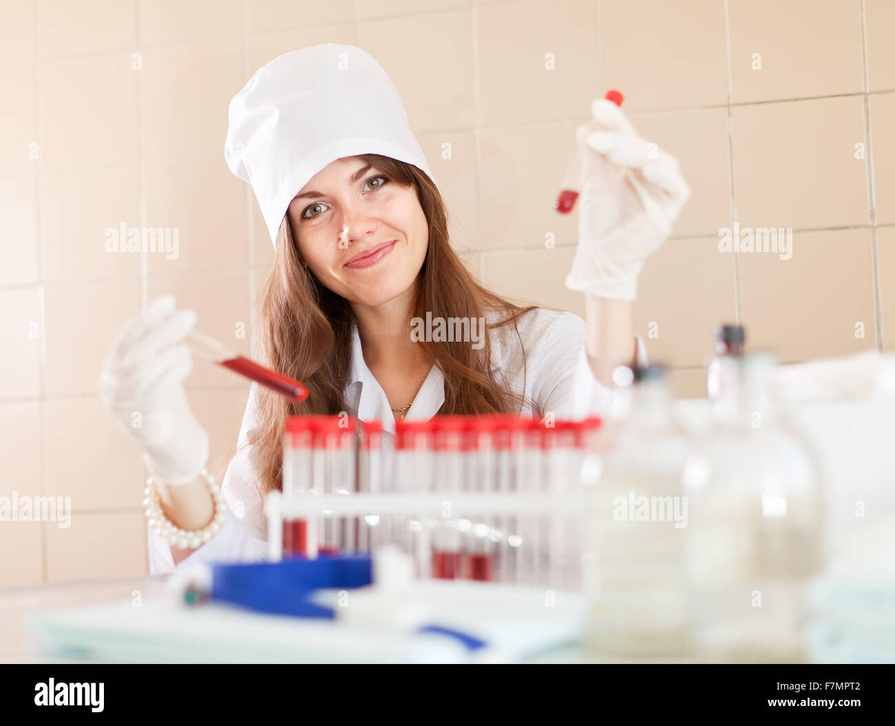 Positive nurse with test tubes in laboratory Stock Photo - Alamy