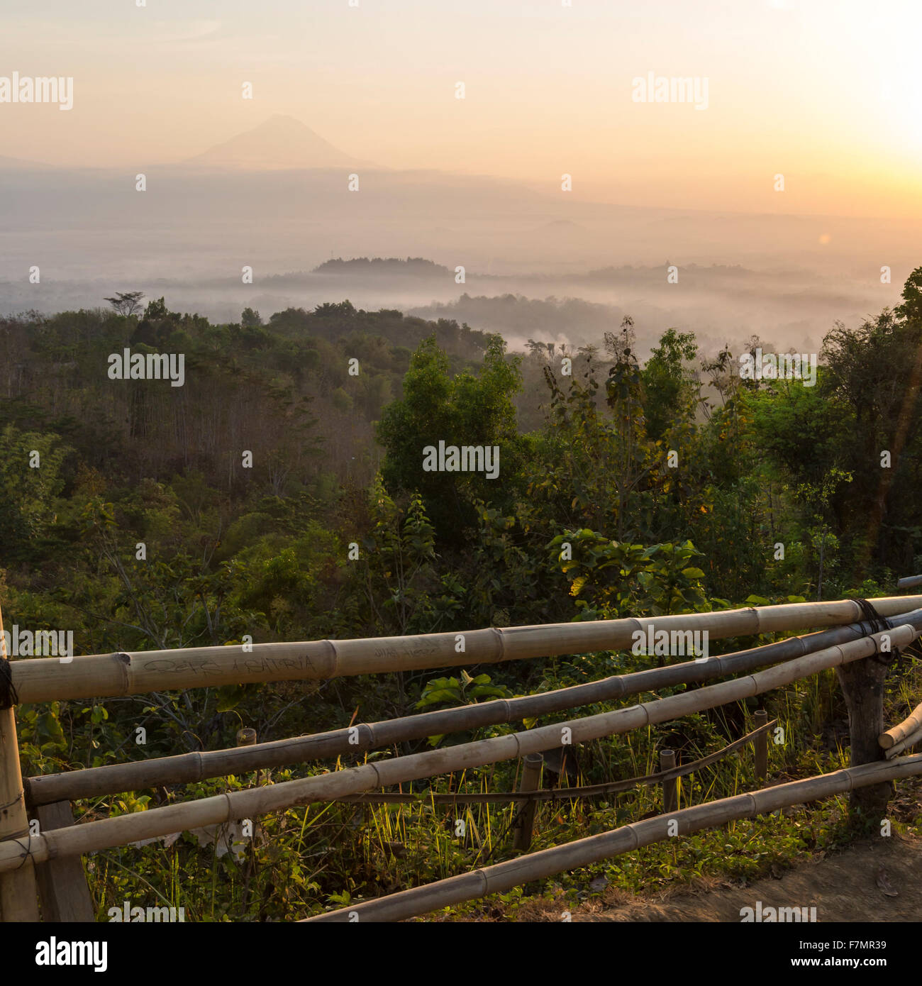 Colorful sunrise over Merapi volcano and Borobudur temple in misty ...