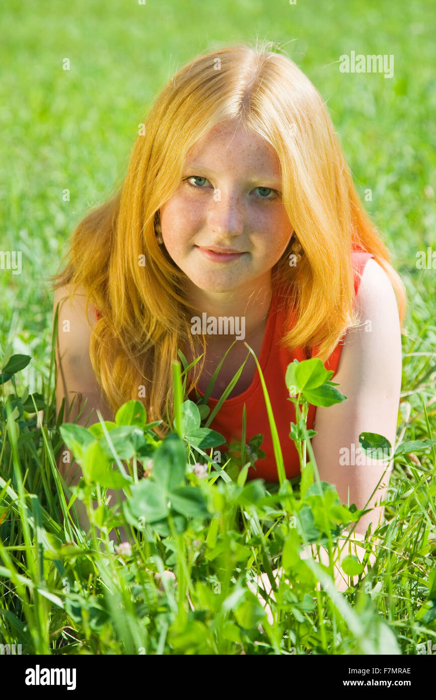 Red-haired teen girl is lying in grass Stock Photo - Alamy