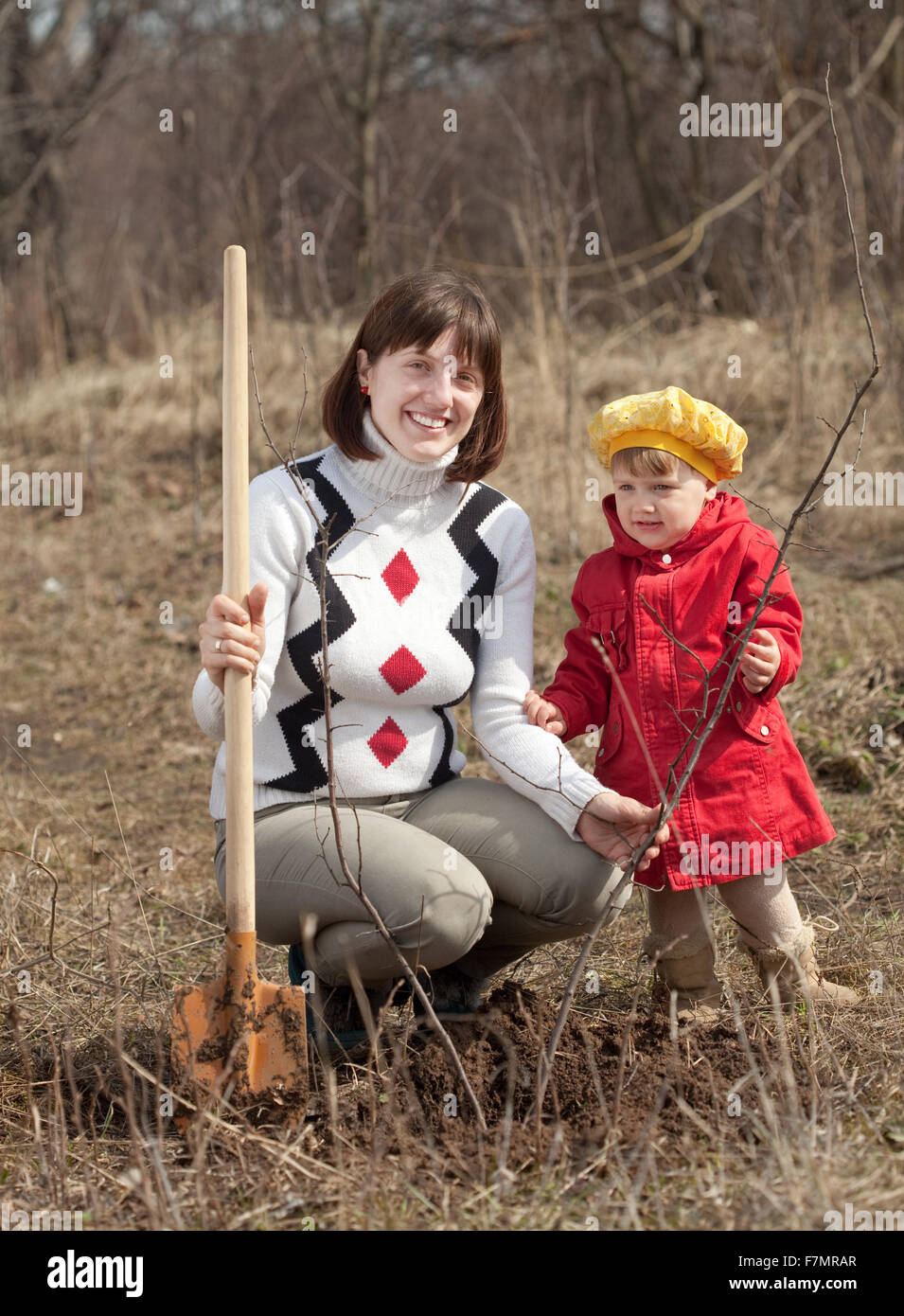 young woman with baby girl planting the tree outdoor Stock Photo - Alamy