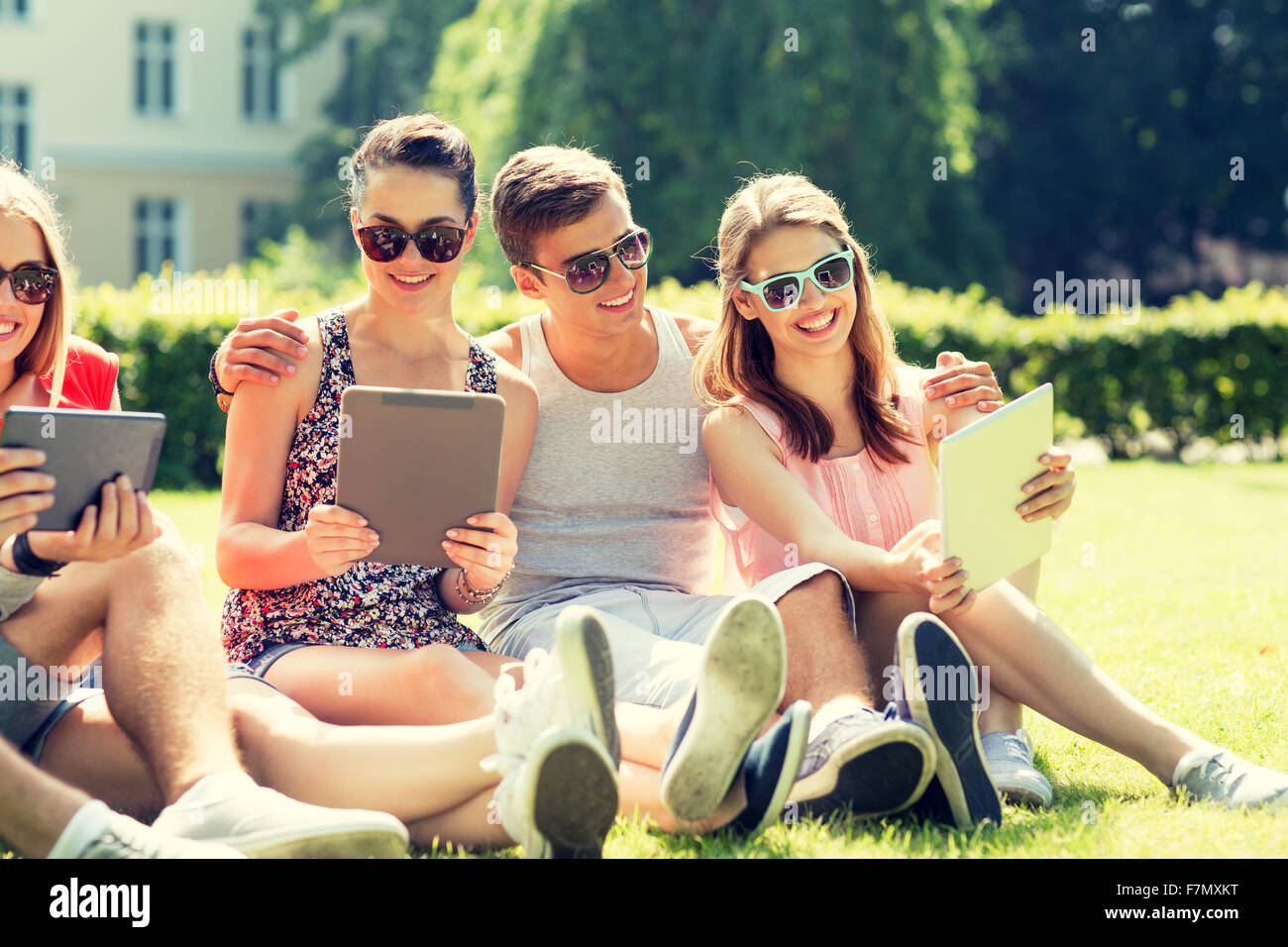smiling friends with tablet pc computers in park Stock Photo - Alamy