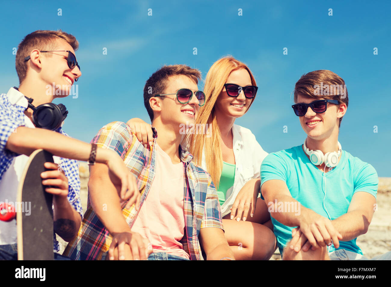 group of smiling friends sitting on city street Stock Photo - Alamy