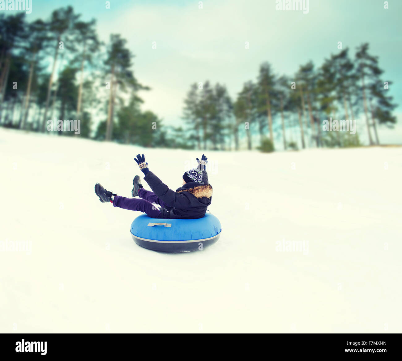 happy young man sliding down on snow tube Stock Photo - Alamy