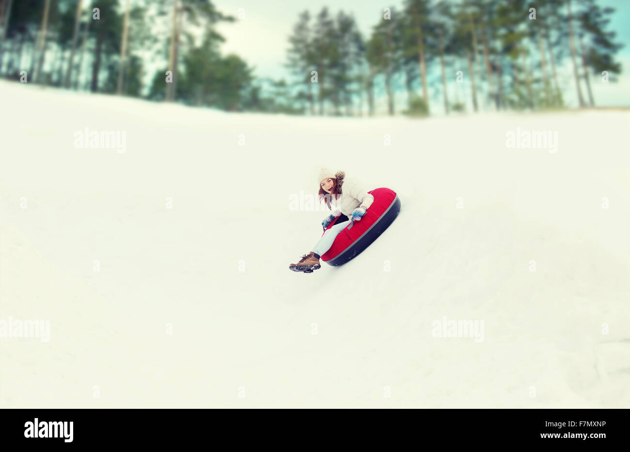 happy teenage girl sliding down on snow tube Stock Photo - Alamy