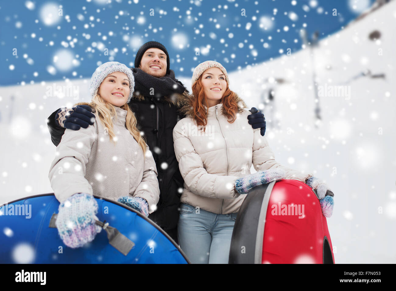 group of smiling friends with snow tubes Stock Photo - Alamy