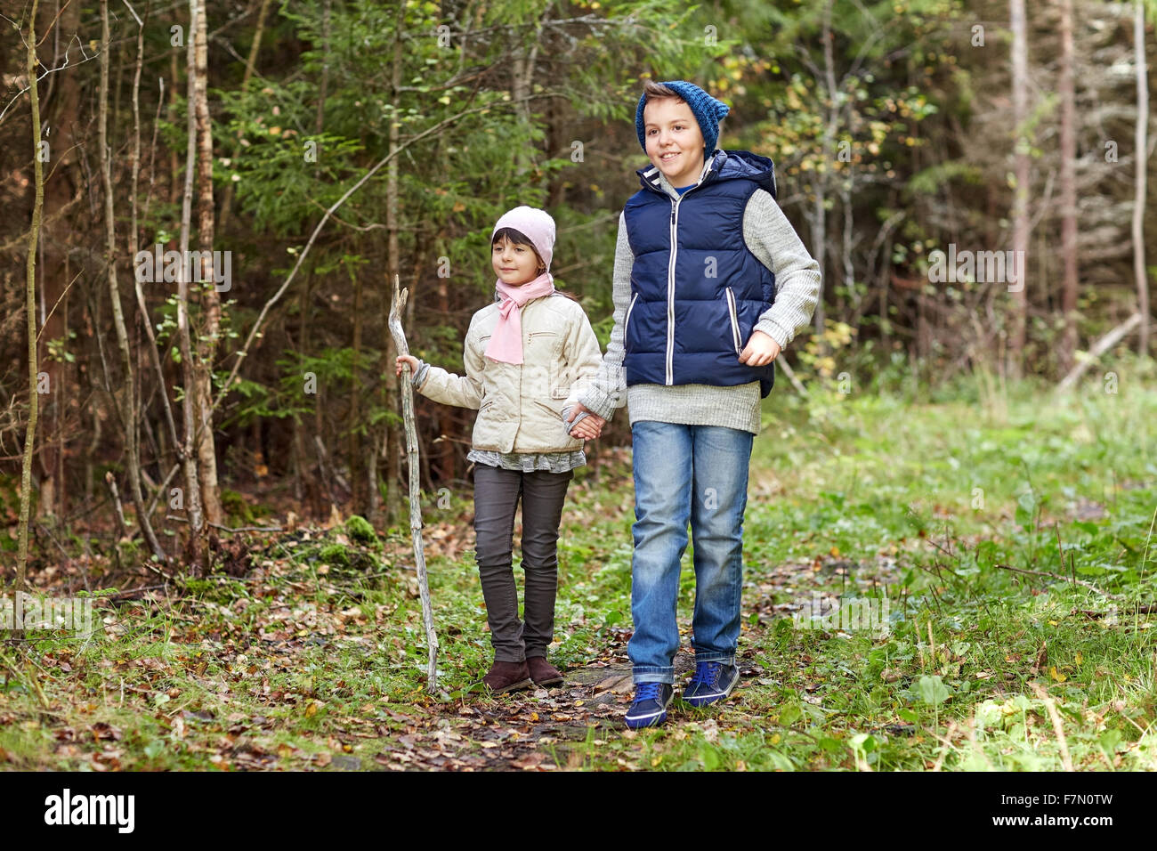 two happy kids walking along forest path Stock Photo - Alamy