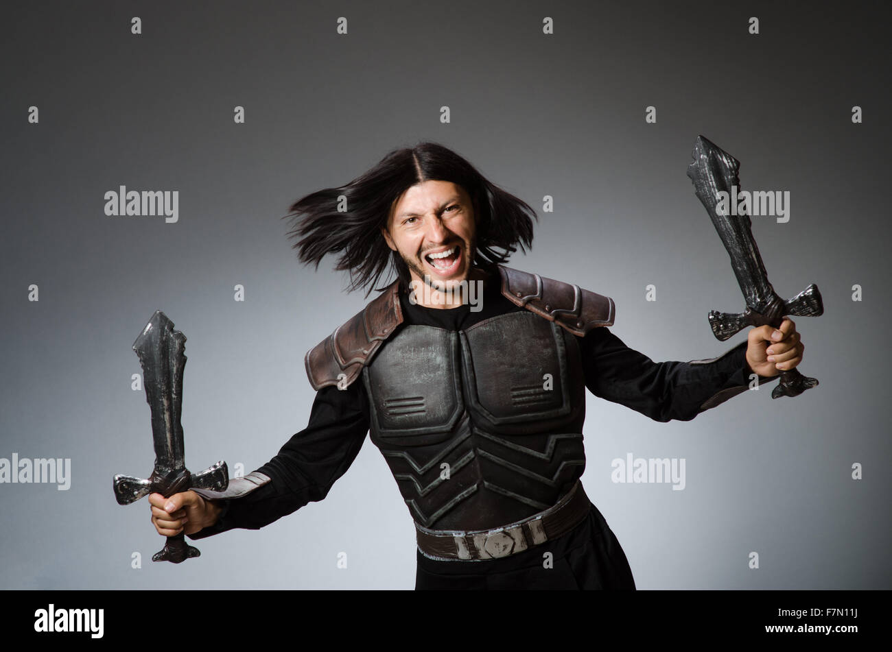 Angry knight with sword against dark background Stock Photo - Alamy