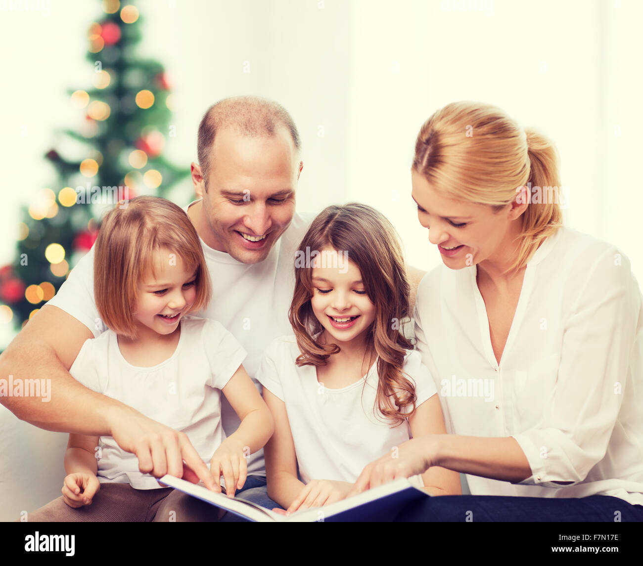 happy family with book at home Stock Photo - Alamy