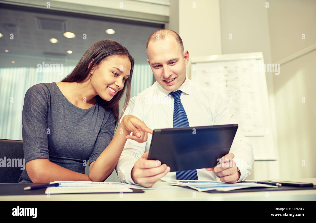 smiling businesspeople with tablet pc in office Stock Photo - Alamy