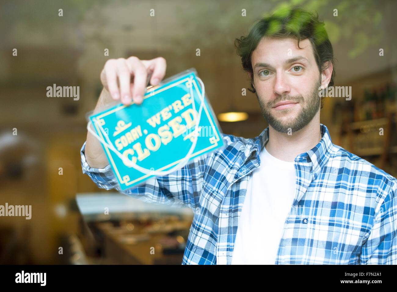 Shopkeeper closing shop for the day Stock Photo - Alamy