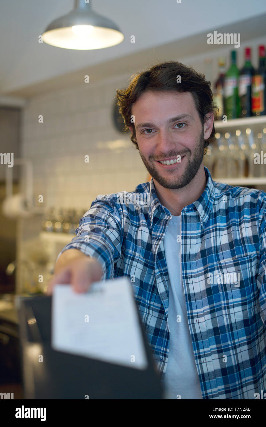 Shopkeeper giving receipt to customer Stock Photo - Alamy