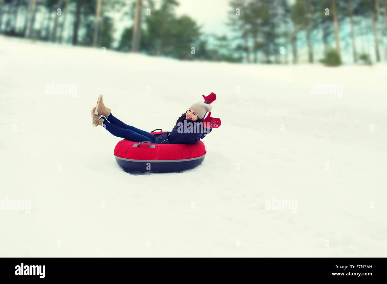 happy teenage girl sliding down on snow tube Stock Photo - Alamy
