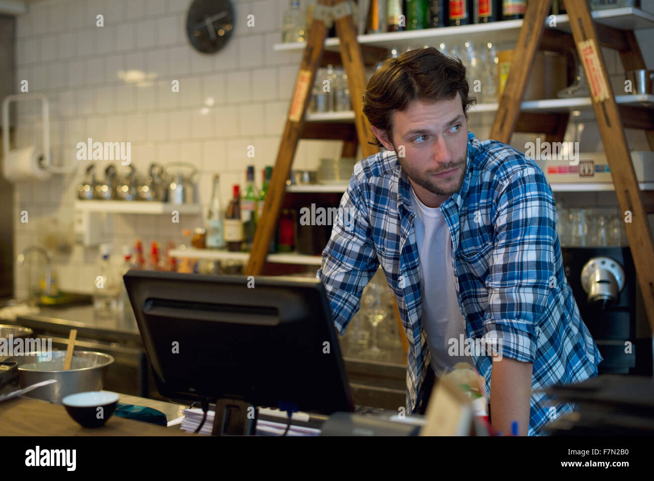 Cafe owner standing behind cash register Stock Photo - Alamy