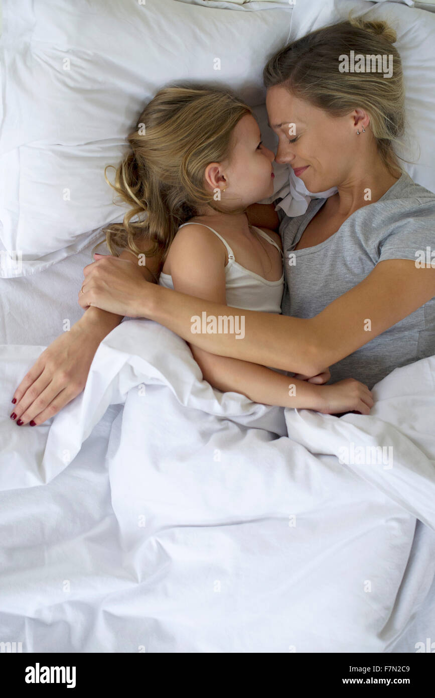 Mother and daughter in bed embracing Stock Photo - Alamy