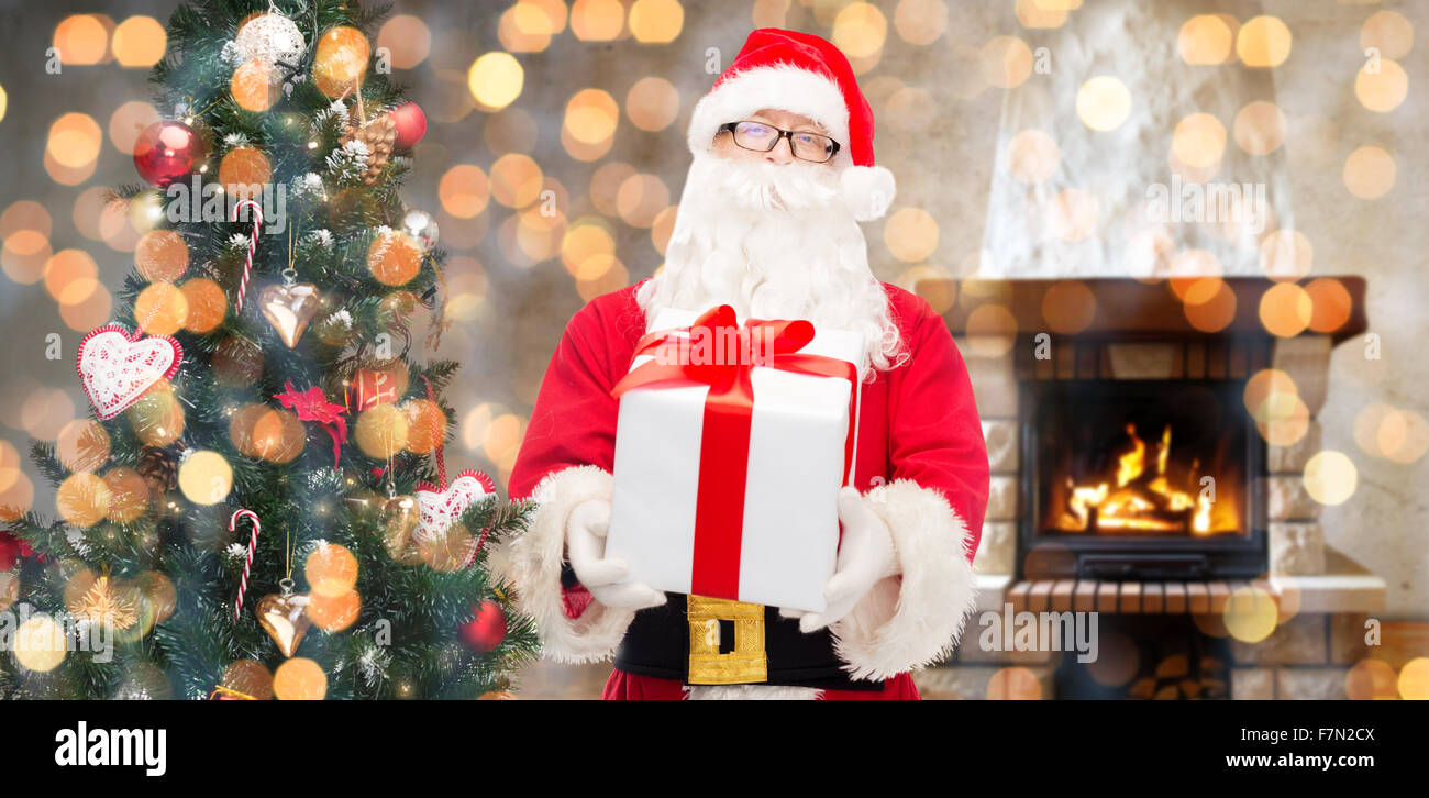 santa claus with gift and christmas tree at home Stock Photo - Alamy