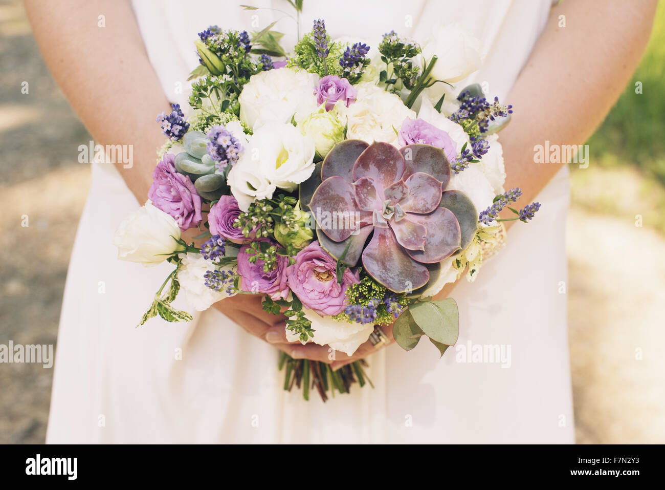 Bride holding bouquet of flowers and succulent plants, cropped Stock ...