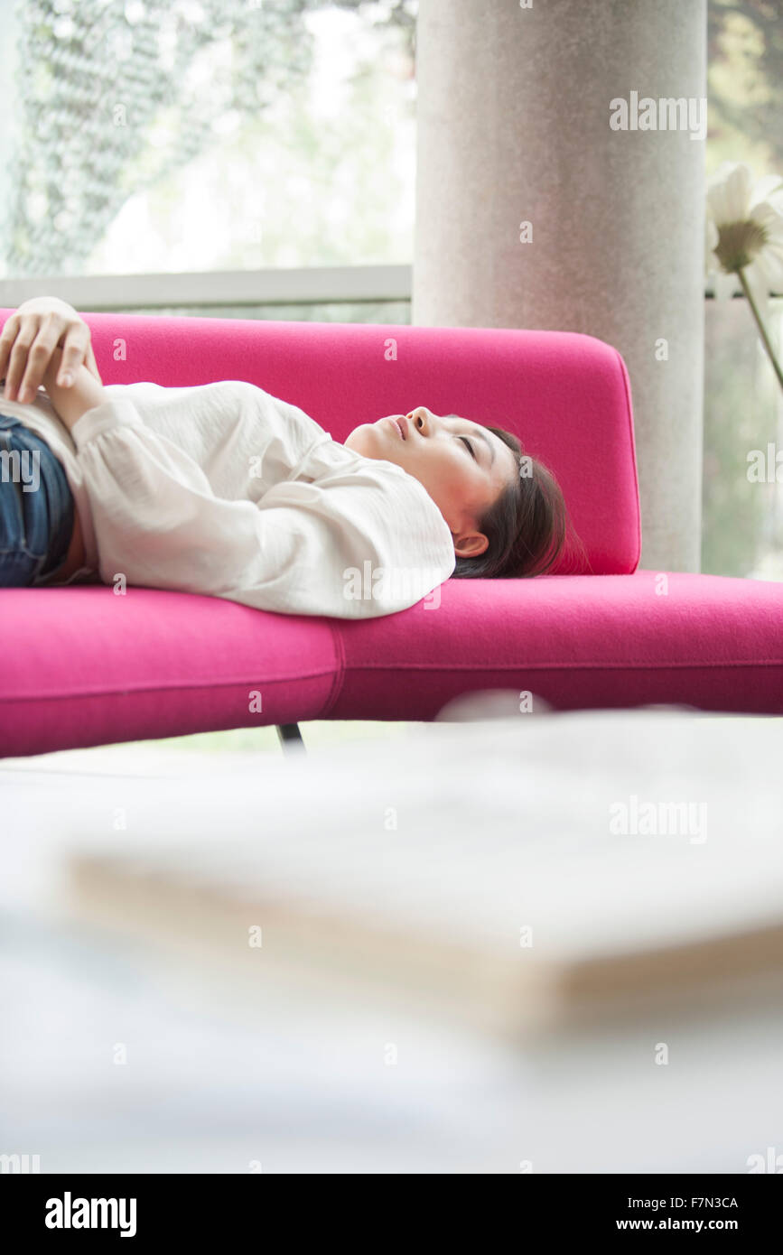 Young woman naps on couch hi-res stock photography and images - Alamy