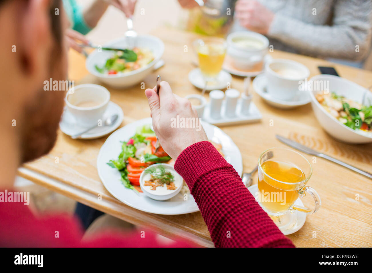 close up friends having dinner at restaurant Stock Photo - Alamy