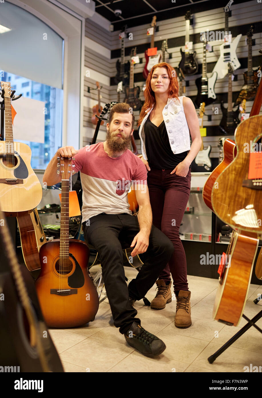 couple of musicians with guitar at music store Stock Photo - Alamy
