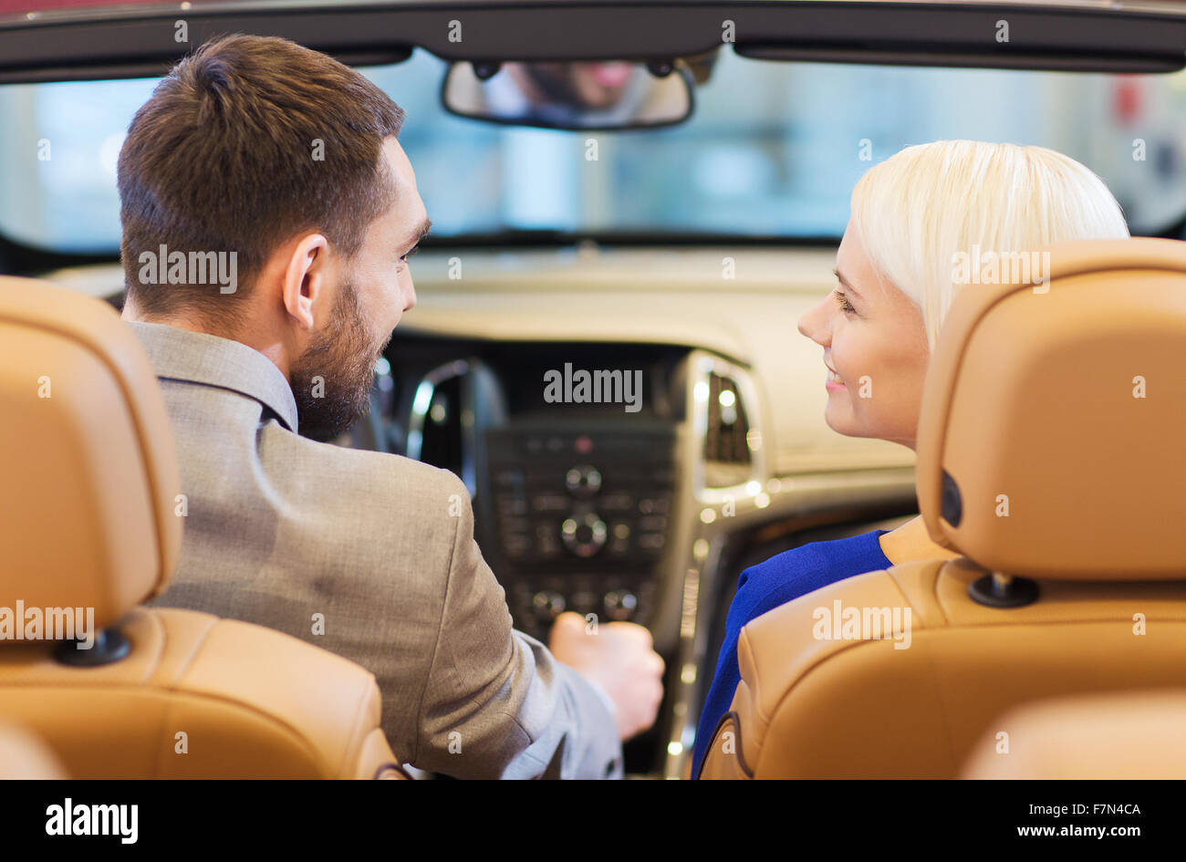 happy couple sitting in car at auto show or salon Stock Photo - Alamy