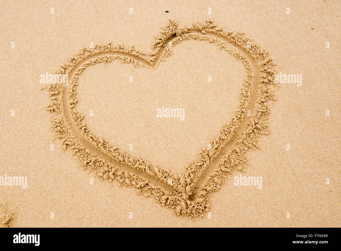 Heart shape drawn in the sand on a beach Stock Photo - Alamy