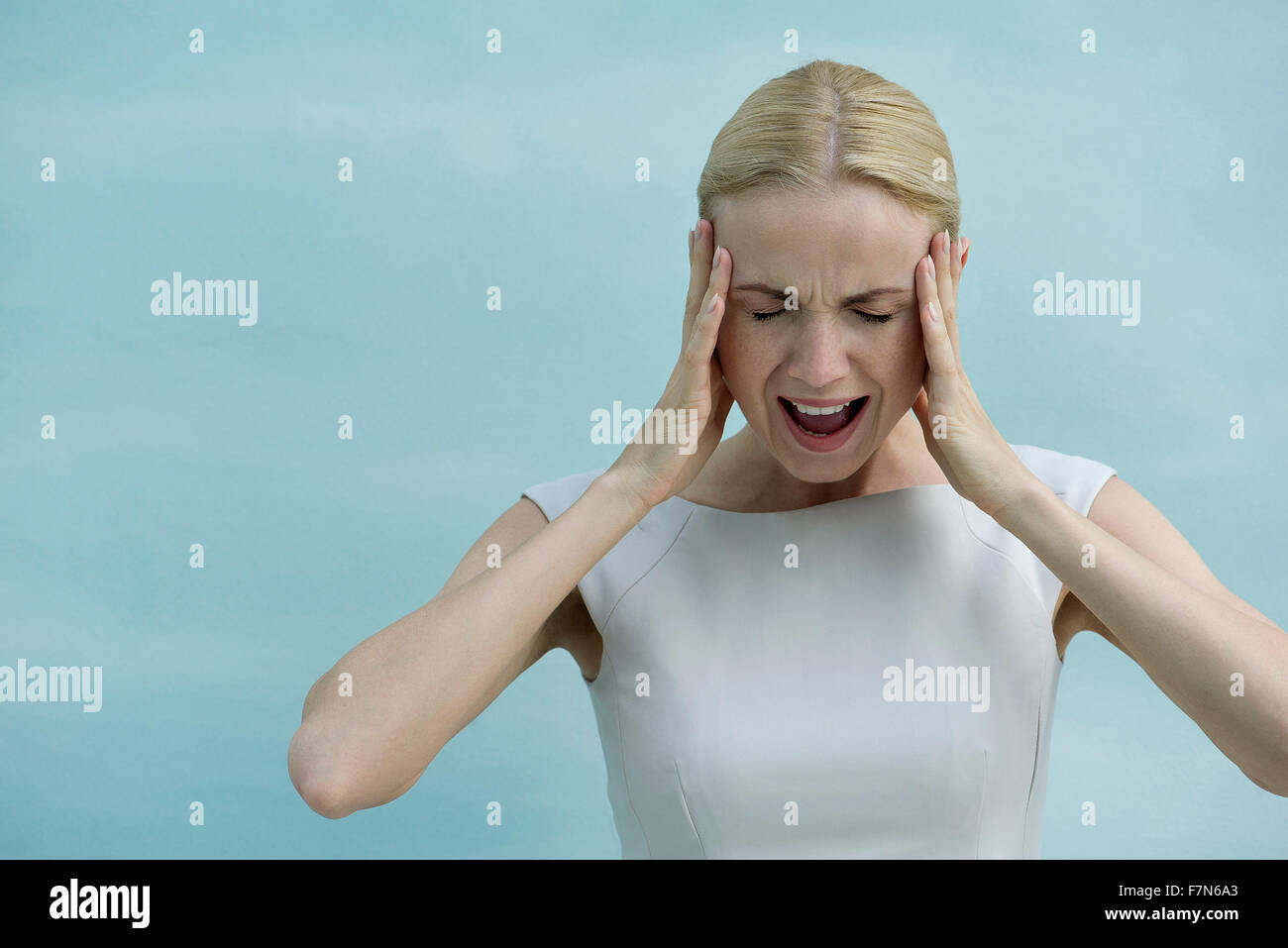 Woman screaming holding head hi-res stock photography and images - Alamy