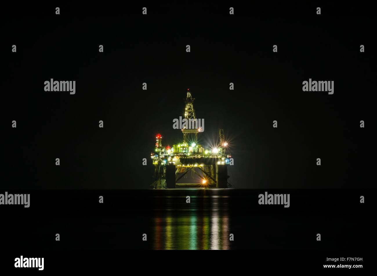 A night view of the oil drilling platform lit up on the coast of ...