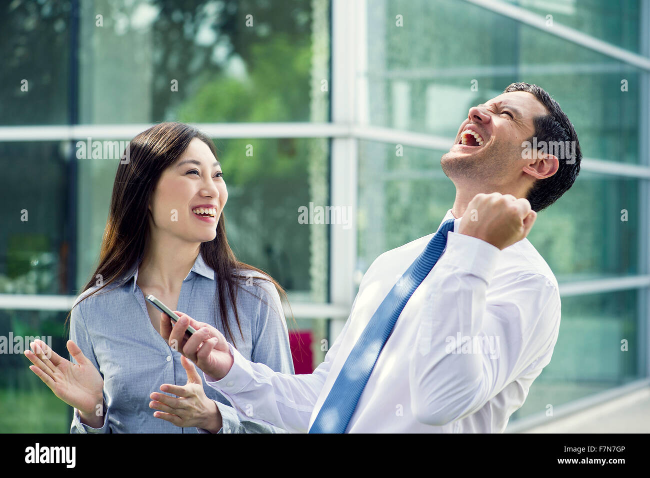 Businessman celebrating good news with colleague Stock Photo - Alamy