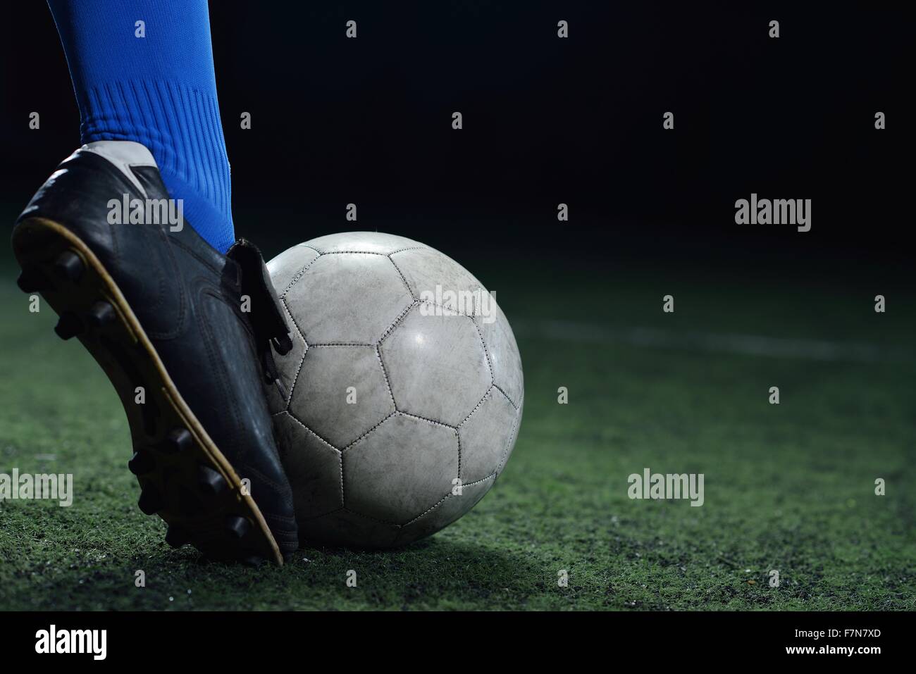 soccer player doing kick with ball on football stadium field isolated ...